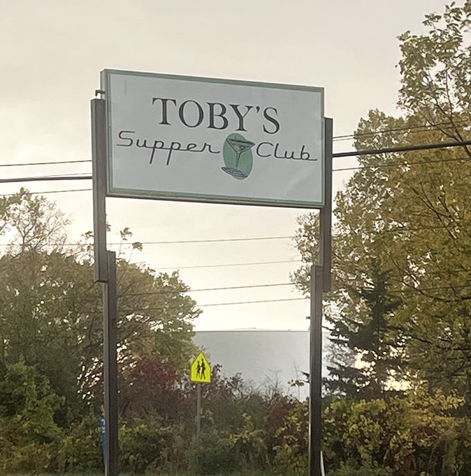 The sign that beckons hungry travelers like a lighthouse guiding ships to safe harbor—except this harbor is filled with fried fish and cocktails.