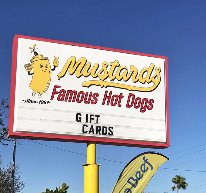 The cheerful mascot on Mustard's sign has been winking at hungry travelers since 1987, promising delicious adventures within.