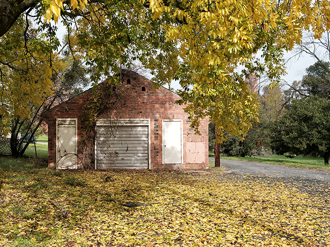 Autumn's golden carpet surrounds this humble brick building&mdash;a scene that whispers "affordable property taxes" to weary urban escapees seeking simpler living.