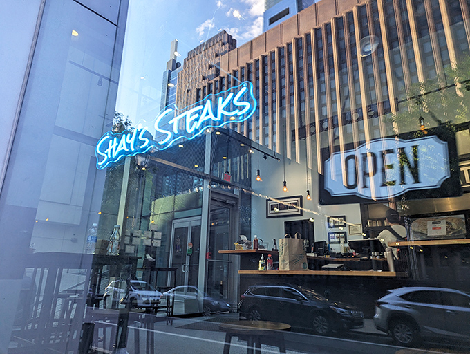 As dusk falls, the neon blue "SHAY'S STEAKS" sign glows like a lighthouse, guiding hungry travelers to safe, delicious harbor.