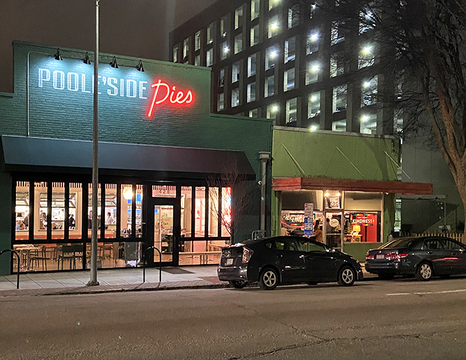 As night falls, Pooleside Pies' neon sign becomes a lighthouse guiding hungry travelers to safe, delicious harbor.