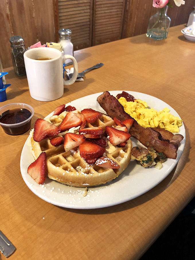 A waffle that's found its soulmate in fresh strawberries. That dusting of powdered sugar is like nature's way of saying "you've made the right choice."