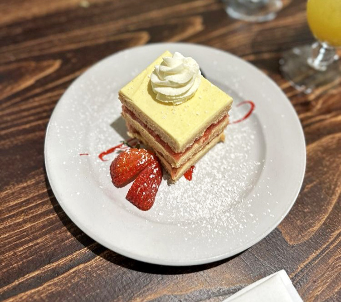 A slice of cake that's dressed better than most of us on a Friday night, with strawberries standing by as willing accomplices.