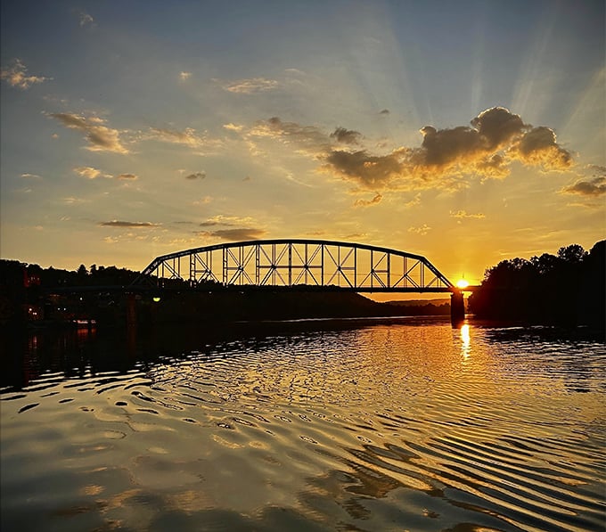 A sunset transforms the river bridge into a perfect silhouette, creating the kind of moment that makes you pull over and just breathe.
