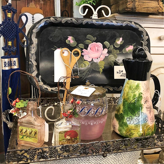 A hand-painted tray surrounded by vintage glassware&mdash;the kind of collection that starts with "just one piece" and somehow becomes your personality.