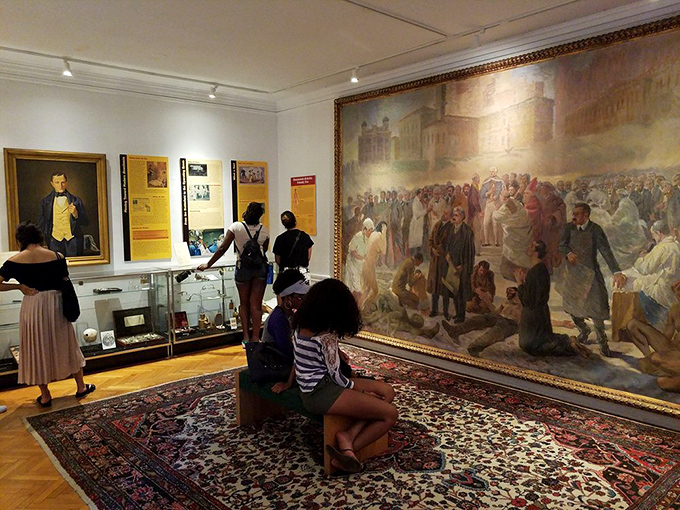 Visitors contemplate a massive medical mural. Art meets science in a room where you can almost hear the whispers of medical history.