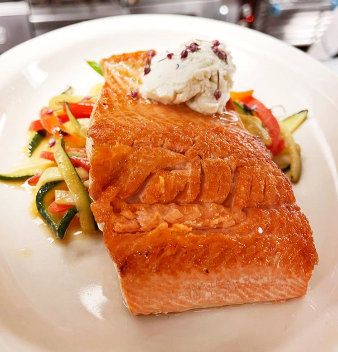 Even the salmon gets the royal treatment, with crispy skin that crackles like nature's potato chip atop buttery fish.