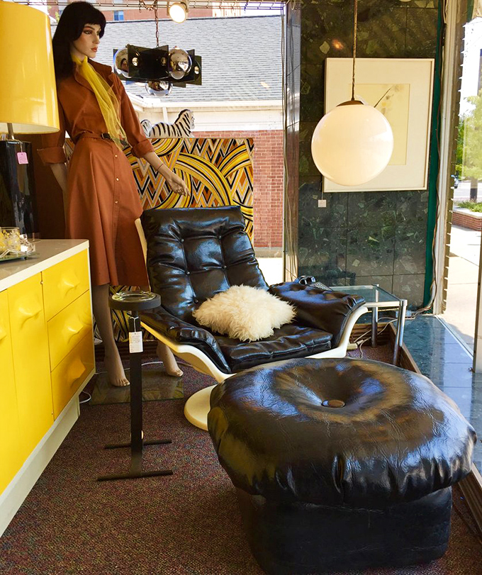 Window display that stops sidewalk traffic with its perfect blend of retro cool. That leather chair isn't just seating&mdash;it's a throne for your living room.