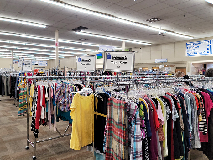 Women's clothing section, where $3 tops mean you can refresh your wardrobe without refinancing your home. Color-coded racks make finding your size a breeze rather than a treasure hunt. 