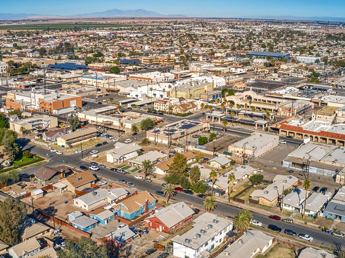 From above, El Centro reveals itself as a perfect grid of desert civilization, surrounded by agricultural fields that stretch toward distant mountains.
