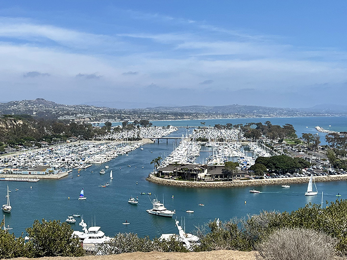 Dana Point Harbor from above looks like a perfectly arranged maritime playground, where boats dance on blue waters and adventures await around every dock.