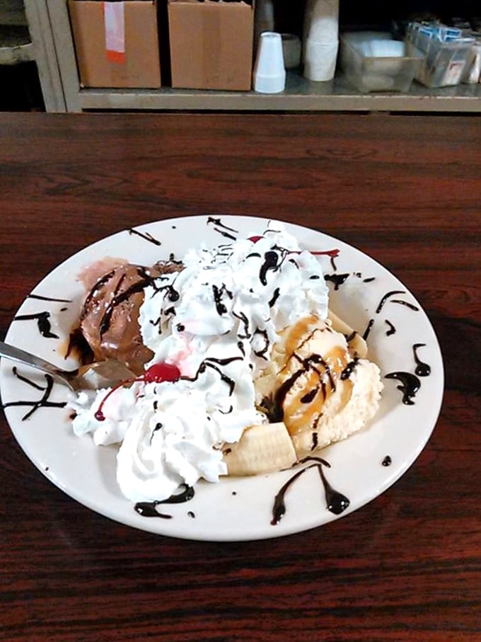 A banana split that defies modern portion control. Ice cream, whipped cream, chocolate drizzle, and fruit&mdash;dessert as it was meant to be before "artisanal" was invented.
