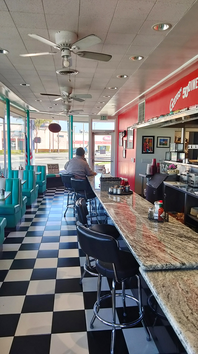 The counter where dreams come true, one plate at a time. That checkered floor has witnessed countless coffee refills and happy conversations.