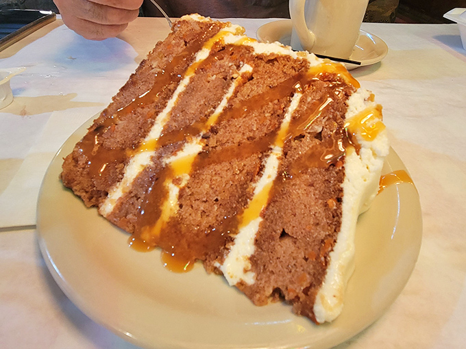 A slice of cake that doesn't believe in moderation. Three layers of "life's too short" topped with caramel that's making a compelling argument against sharing.