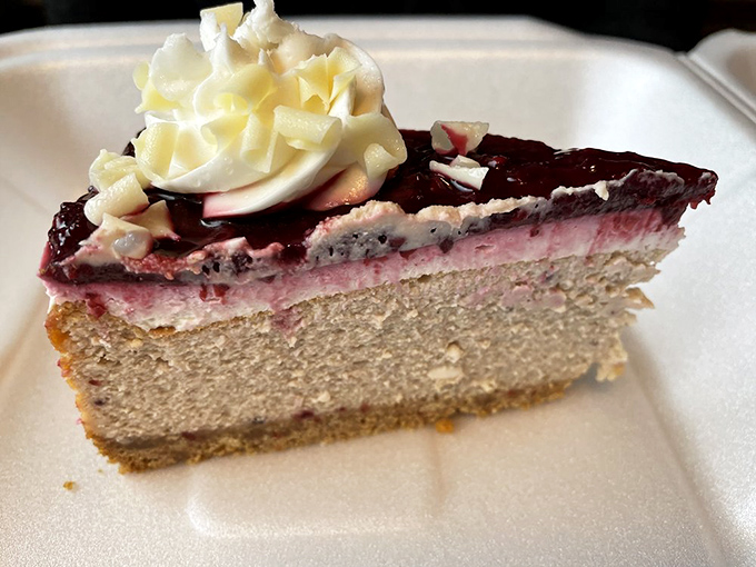 A slice of cheesecake that understands the importance of layers – like a geological marvel of cream cheese, fruit, and whipped cream that's worth every calorie.