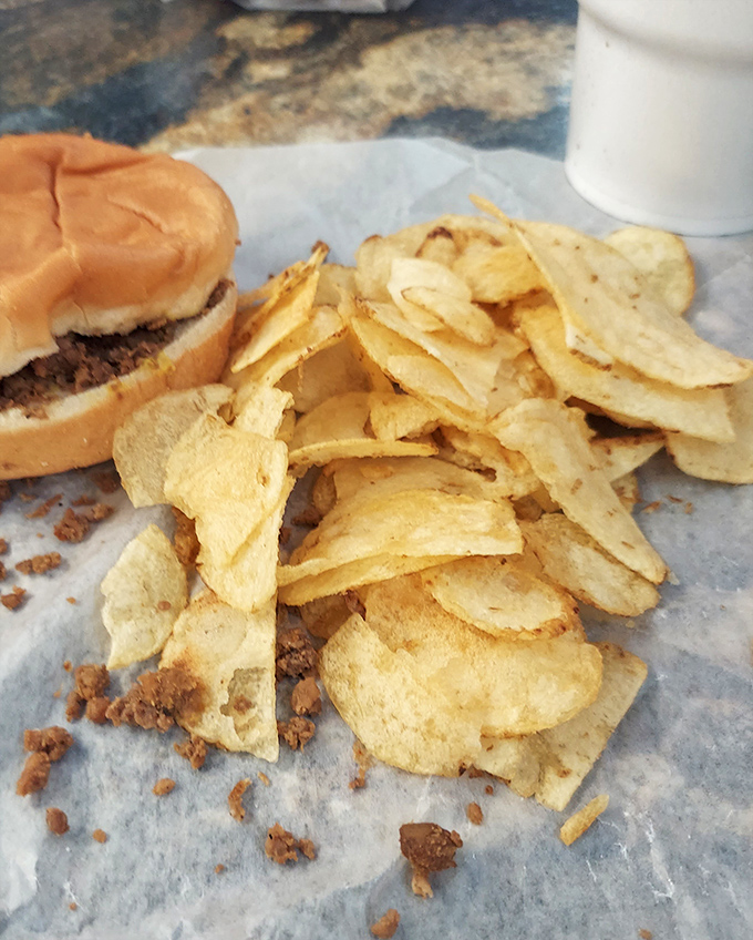 The chips don't fall far from the sandwich! These crispy companions catch stray meat crumbles like tasty little life rafts on a sea of wax paper.