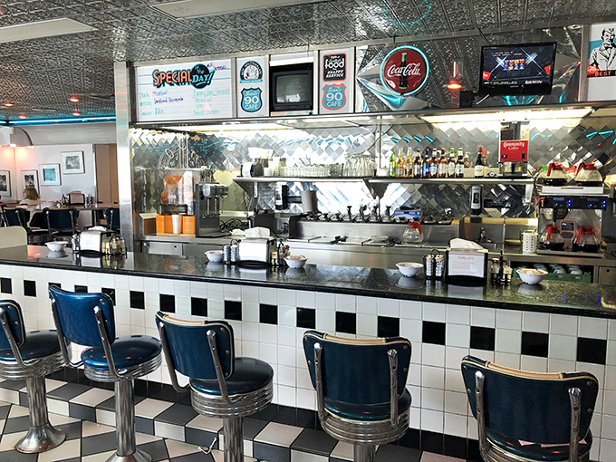 The counter where regulars become family. Blue seats facing the kitchen's choreographed chaos&mdash;the best seats in the house for breakfast theater.