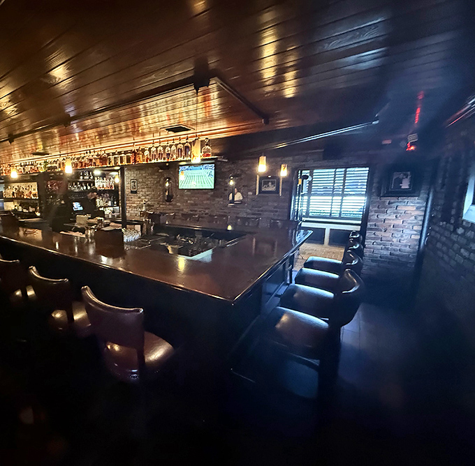 The bar area whispers "come, sit, stay awhile" with the confidence of somewhere that knows exactly what it's doing. Dark wood and amber lights create steakhouse magic.