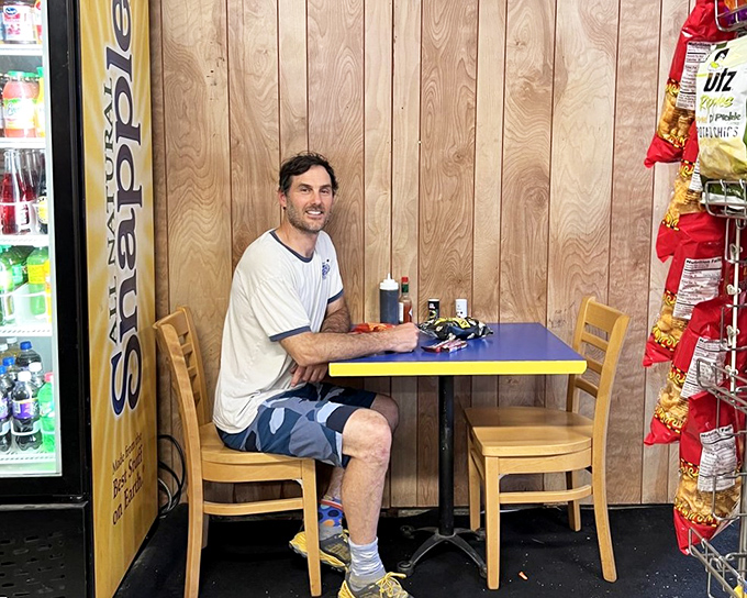 The simple wooden paneling and bright table create the perfect backdrop for burger bliss. Sometimes happiness is just a man and his meal in a moment of pure contentment.