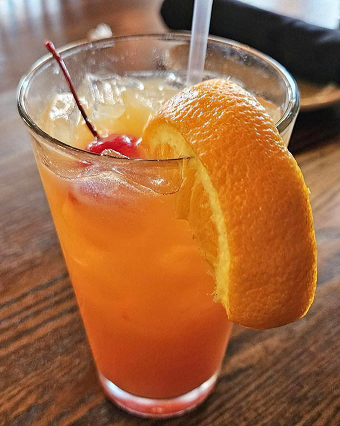 A Hurricane cocktail that's part New Orleans tradition, part fruit-forward refreshment. That orange slice isn't just garnish – it's a promise.