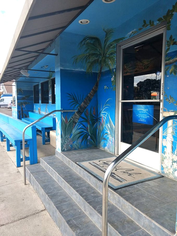 Palm tree murals frame the entrance, setting the scene for the coastal breakfast escape that awaits just beyond those doors.