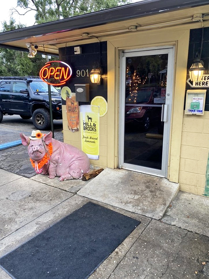 The entrance guarded by a pink pig statue wearing a lei&mdash;because nothing says "serious barbecue" like a dressed-up porcine greeter with attitude.
