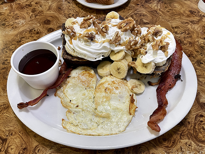 French toast that's having an identity crisis as a dessert, complete with whipped cream, bananas, and walnuts. Breakfast or dessert? Yes, please.