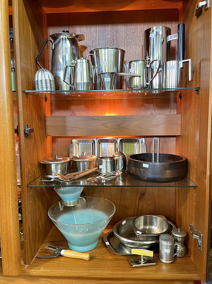 Mid-century serving pieces gleaming on wooden shelves&mdash;ready to elevate your next cocktail party from "we bought plastic cups" to "we have actual martini glasses."