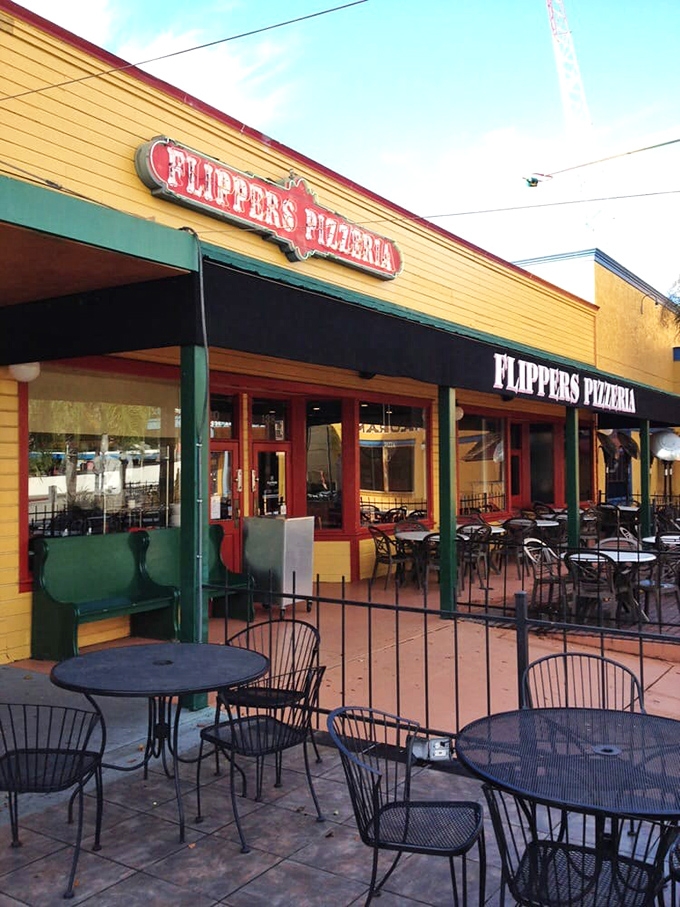 The outdoor seating area&mdash;where the yellow building and green accents create a tropical vibe perfect for pizza paradise.