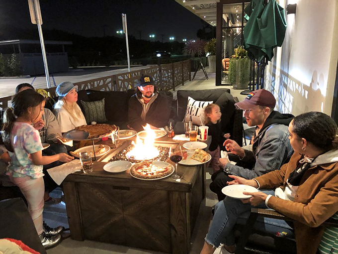 As evening falls, the fire tables transform outdoor dining into a magical experience where pizza, conversation, and laughter blend into the perfect night out.