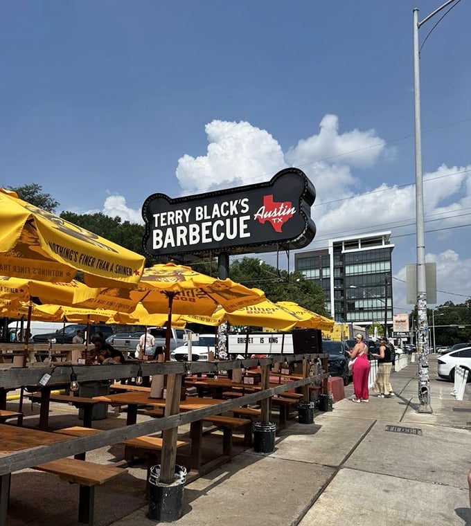 Yellow umbrellas provide shade for the serious business of enjoying Texas barbecue. The outdoor dining area offers a front-row seat to Austin's vibrant street life.