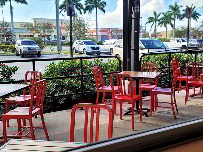 Outdoor seating where Florida's sunshine and barbecue's smoke create the perfect marriage. Those red chairs aren't just furniture&mdash;they're front-row seats to flavor town.