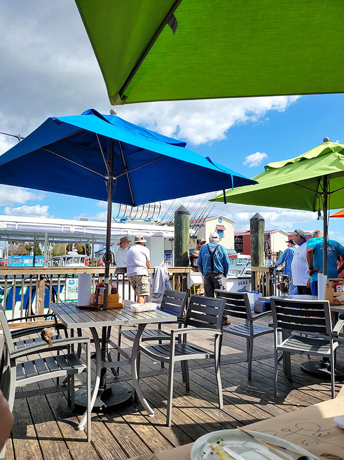 The outdoor deck at Pinchers offers front-row seats to Florida's perfect weather, with colorful umbrellas providing just enough shade for comfortable dining.