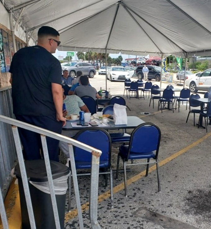 Outdoor dining under a simple tent &ndash; because great seafood needs no fancy setting. Island vibes and satisfied diners prove atmosphere comes from the plate.