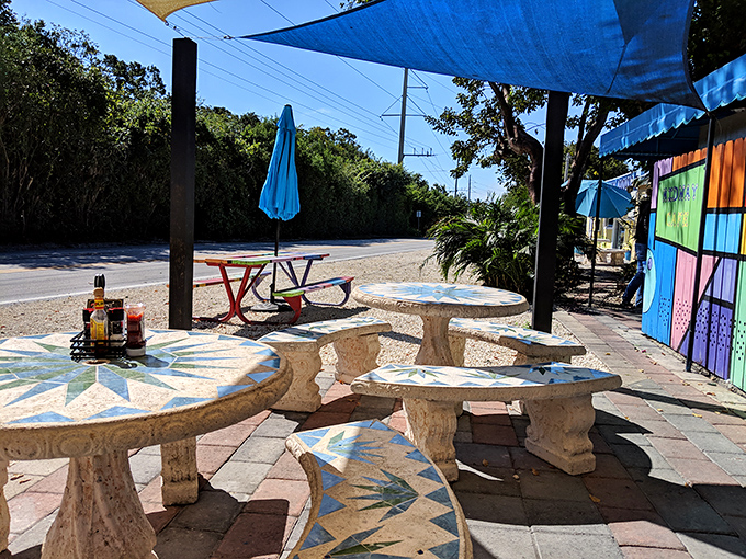 Outdoor seating that captures the essence of Keys dining&mdash;casual, colorful tables under blue shade sails where time slows down and flavors intensify.