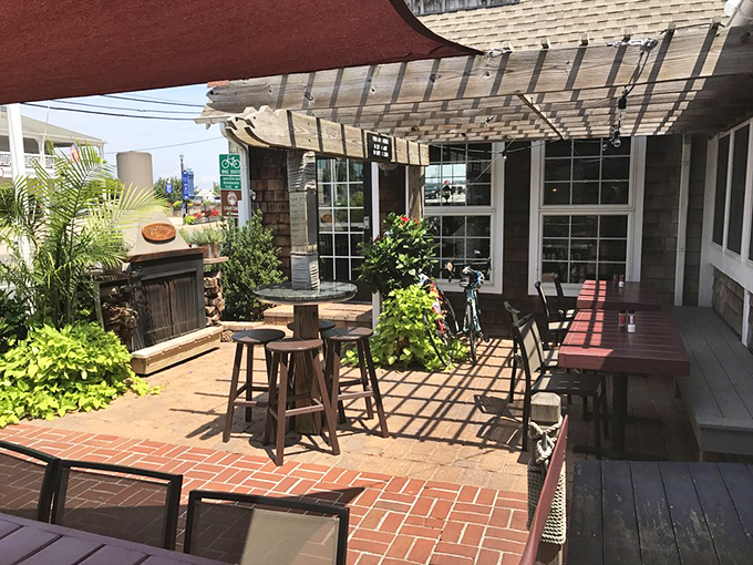 The outdoor patio&mdash;where salt air enhances every bite, and the pergola creates dancing shadows that make your cocktail taste even better.