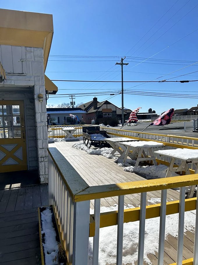 Yellow-trimmed outdoor seating awaits weary travelers, offering a moment of respite and the perfect spot to savor your newly acquired treats.