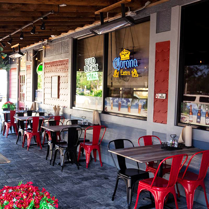 The outdoor seating area with those signature red chairs&mdash;where gentle Florida breezes enhance every bite and no one rushes you through your seafood bliss.