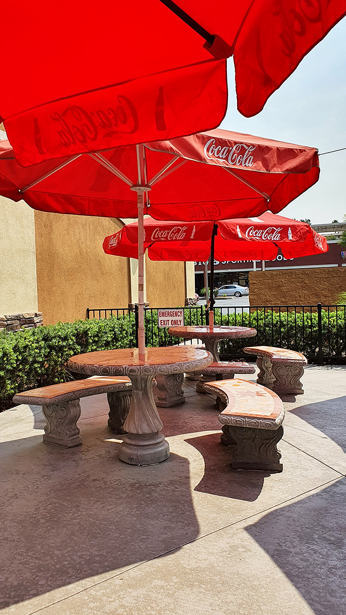 Outdoor seating under Coca-Cola umbrellas&mdash;where California sunshine meets diner classics. These stone tables have hosted countless conversations, both profound and delightfully trivial.