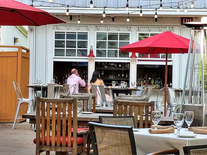Red umbrellas add pops of color to the outdoor dining area&mdash;a perfect setting for those summer evenings when eating indoors seems criminal.