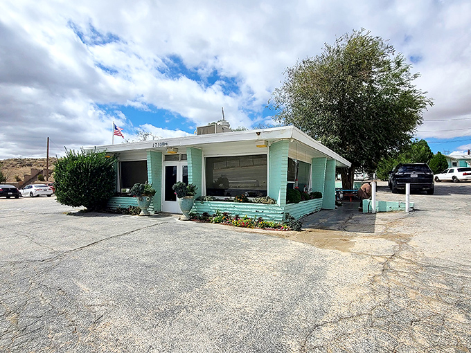 The mint green exterior sits like a jewel in the desert, promising refuge and sustenance to weary travelers.