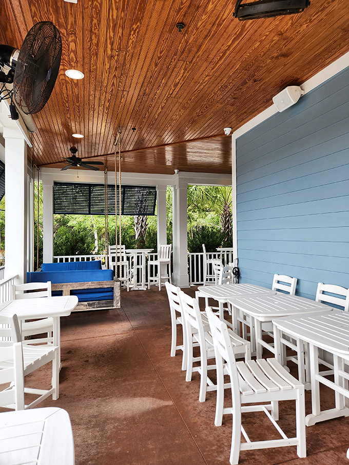 The porch: where coastal breezes meet culinary excellence. White wooden furniture and blue walls create the perfect setting for al fresco seafood feasting.