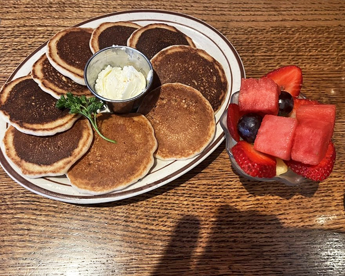 These aren't just pancakes; they're edible frisbees of joy that somehow taste even better than they look, especially with fresh fruit alongside.