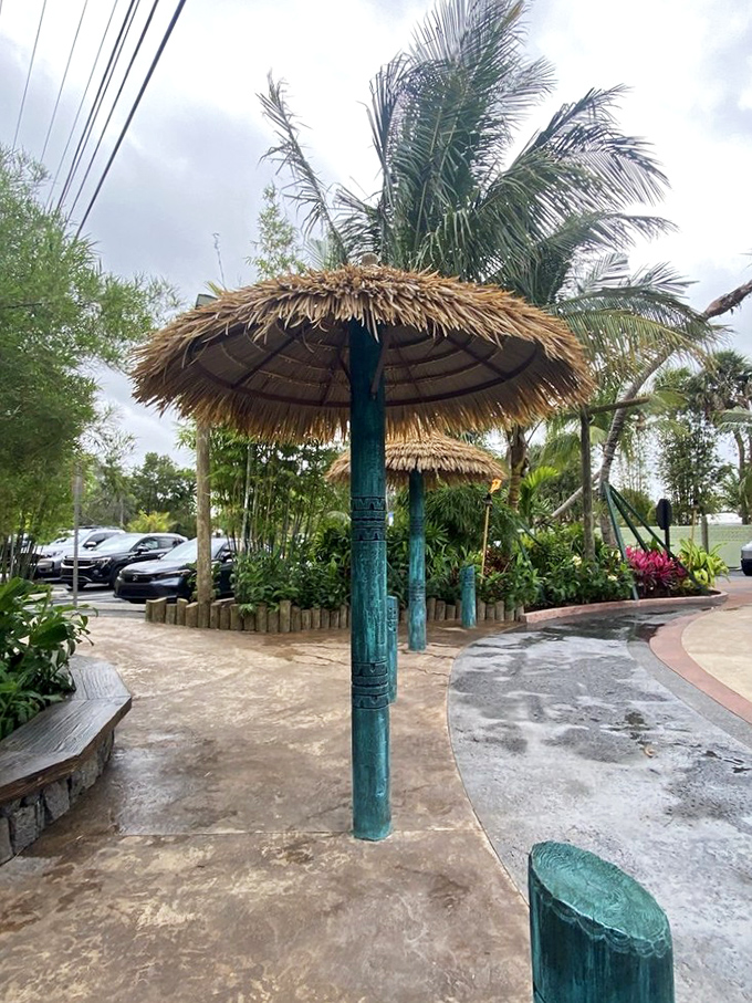 Even the parking area maintains the illusion. Palm-thatched umbrellas transform the mundane act of parking into the first step of your Polynesian journey.