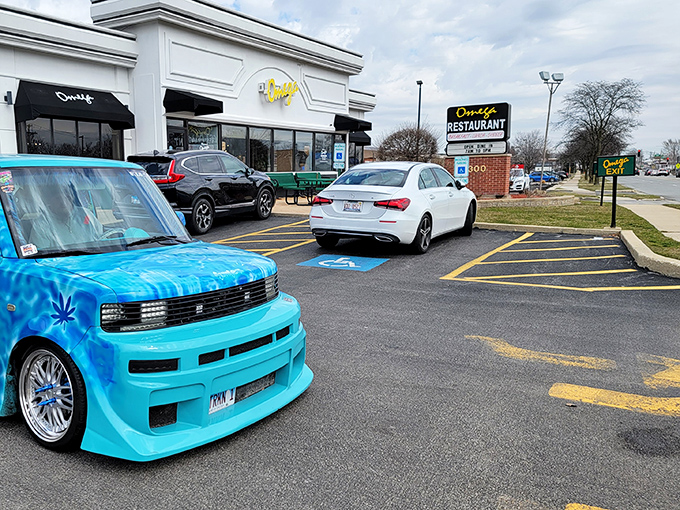 A parking lot that's seen generations of hungry visitors. That blue car seems to understand the urgency of getting inside for a proper meal.