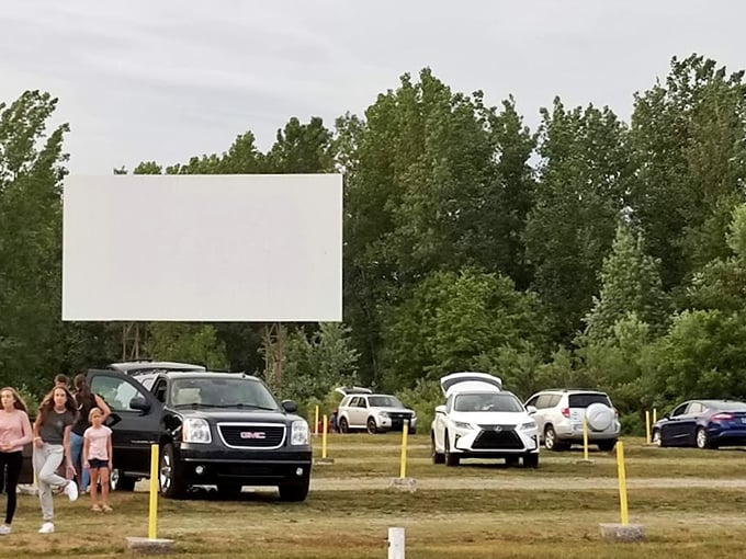 Cars arrange themselves in neat rows, anticipating the show to come. The blank screen waits patiently for dusk&mdash;when the real magic begins.