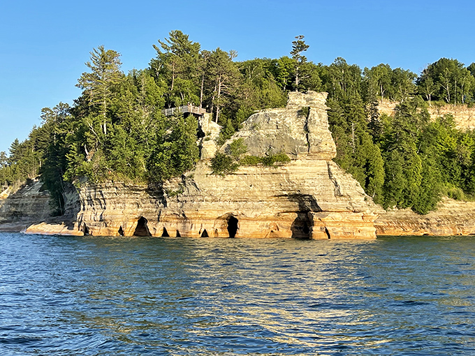 Miners Castle stands proudly above the water, its layered sandstone face resembling nature's attempt at creating the perfect layer cake.