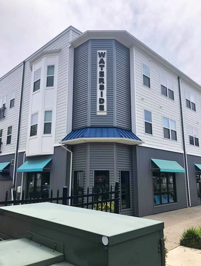 The building stands proud on its corner, with "WATERSIDE" announcing itself like a friendly neighbor who always has coffee ready when you visit.