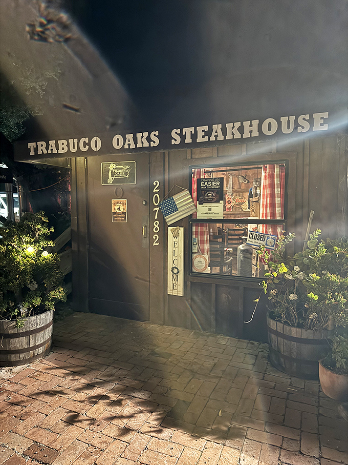 As night falls, the illuminated entrance glows like a beacon for hungry travelers. The steakhouse equivalent of "Follow the light."