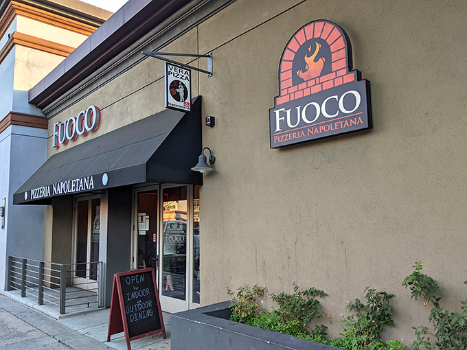 The storefront may be unassuming, but that logo tells you everything &ndash; fire-kissed pizza made with passion awaits just beyond those doors.